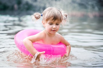 little girl in pink inner tube - UrbanMoms